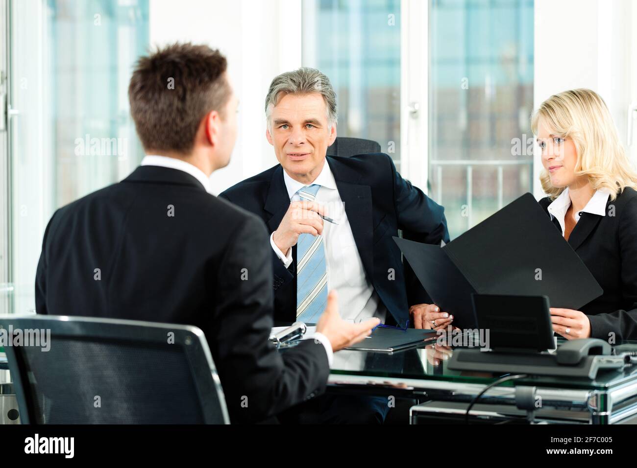 Business - young man sitting in job Interview Stock Photo - Alamy