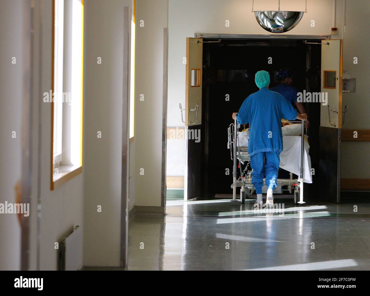 Healthcare staff transporting a patient in a hospital bed, Linköping ...
