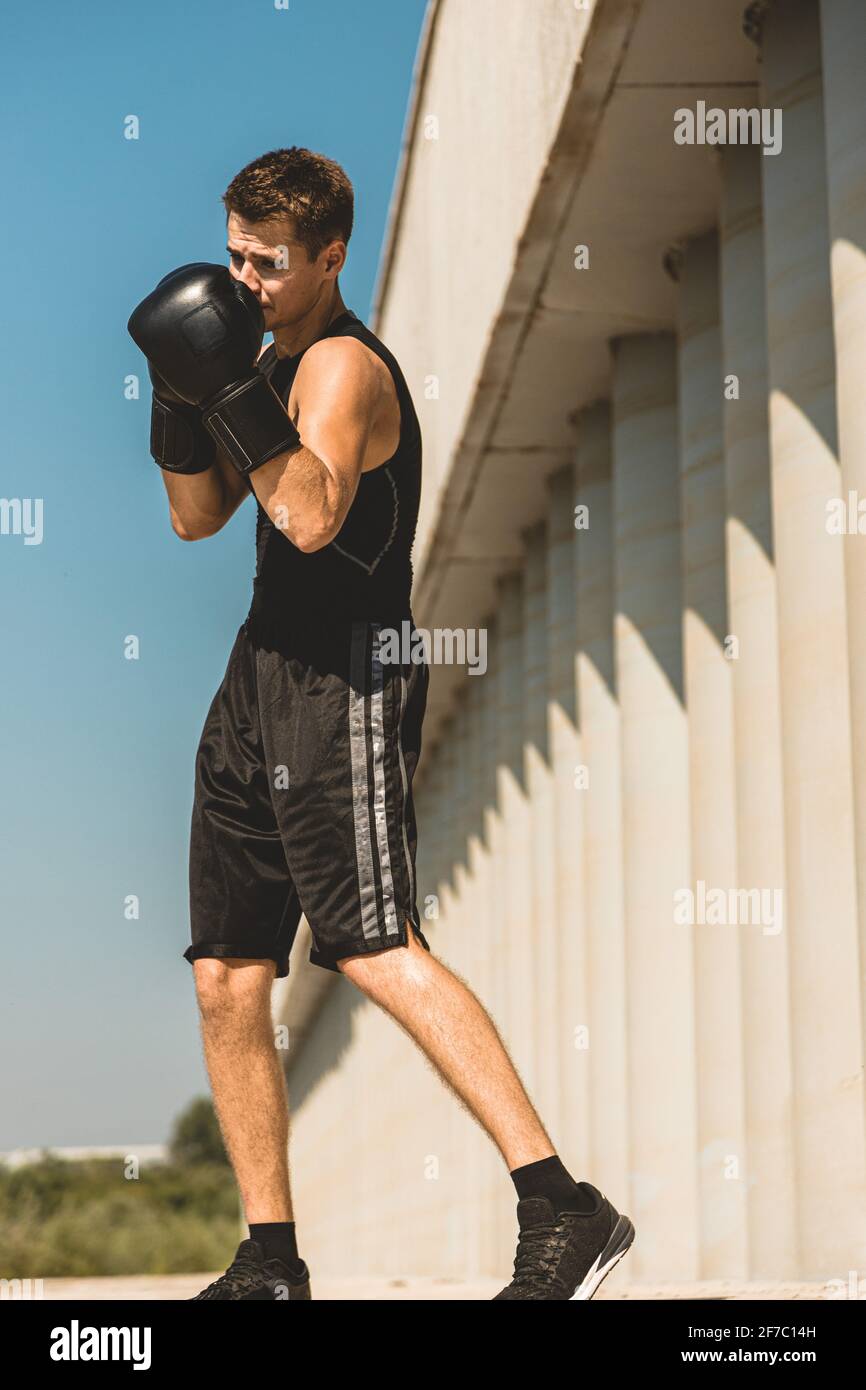 Man exercising and fighting in outside, boxer in gloves. male boxer ...