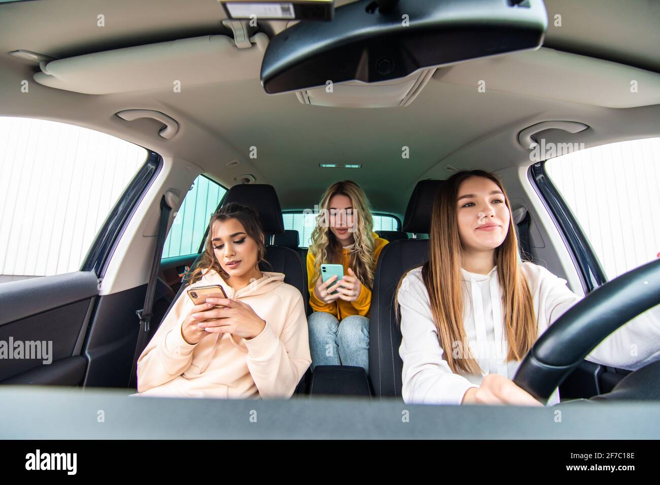 Three best friends in the car and use smart phone while drive car Stock ...