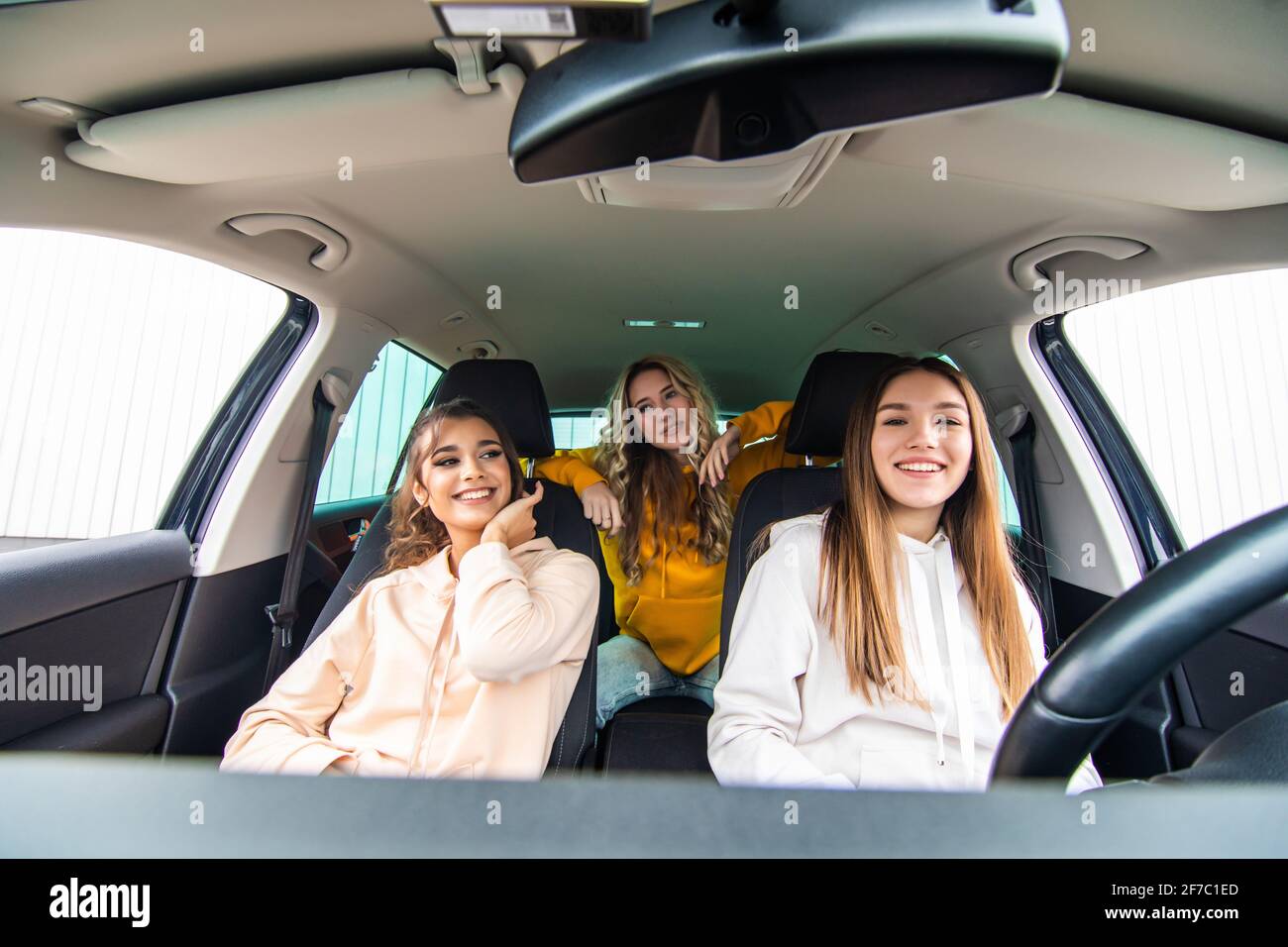 three girls driving in a convertible car and having fun Stock Photo - Alamy