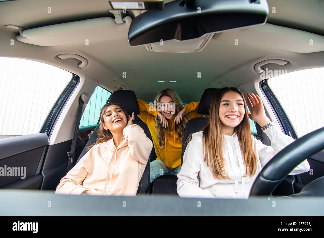 three girls driving in a convertible car and having fun Stock Photo - Alamy