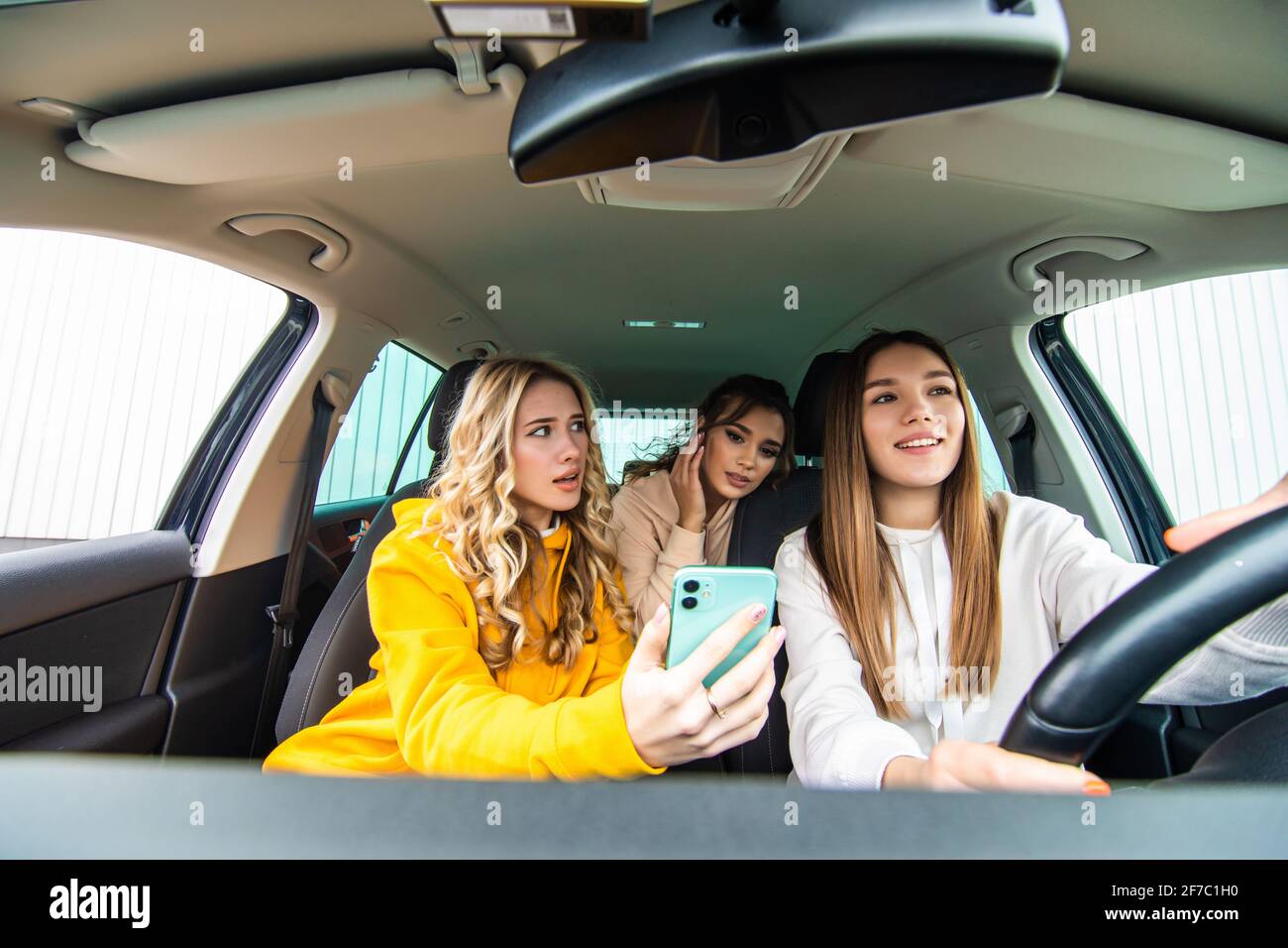 Three best friends in the car and riding ridiculous message. Girl ...