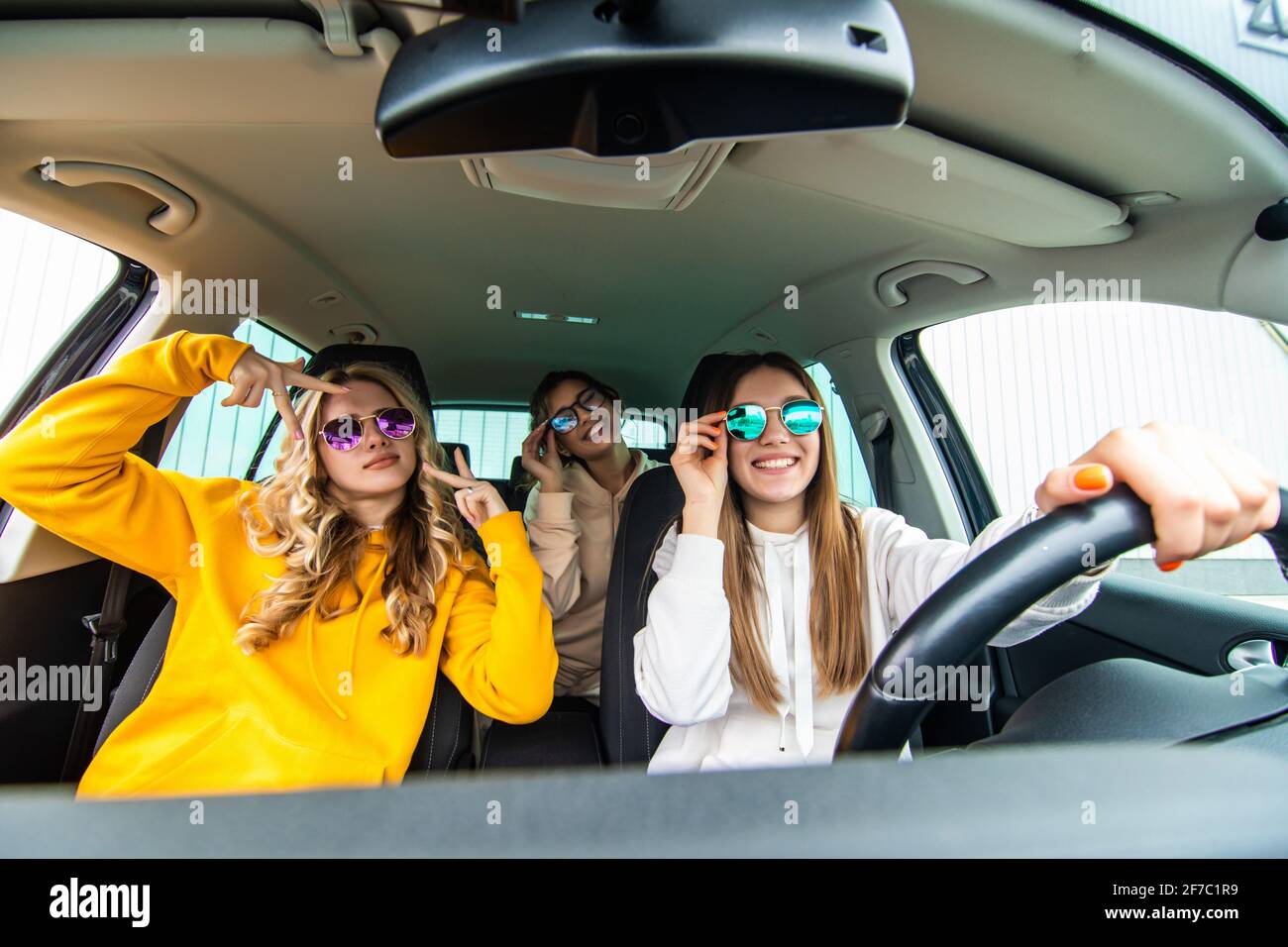 Group of girls having fun in the car. Women friends singing songs and ...