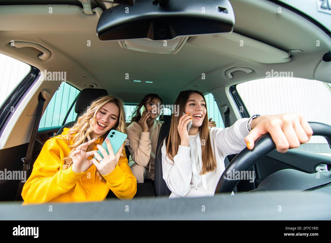 Three best friends in the car and use smart phone while drive car Stock ...