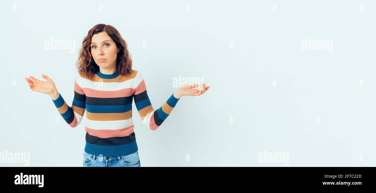 Confused beautiful young woman wearing casual outfit shrugs her ...