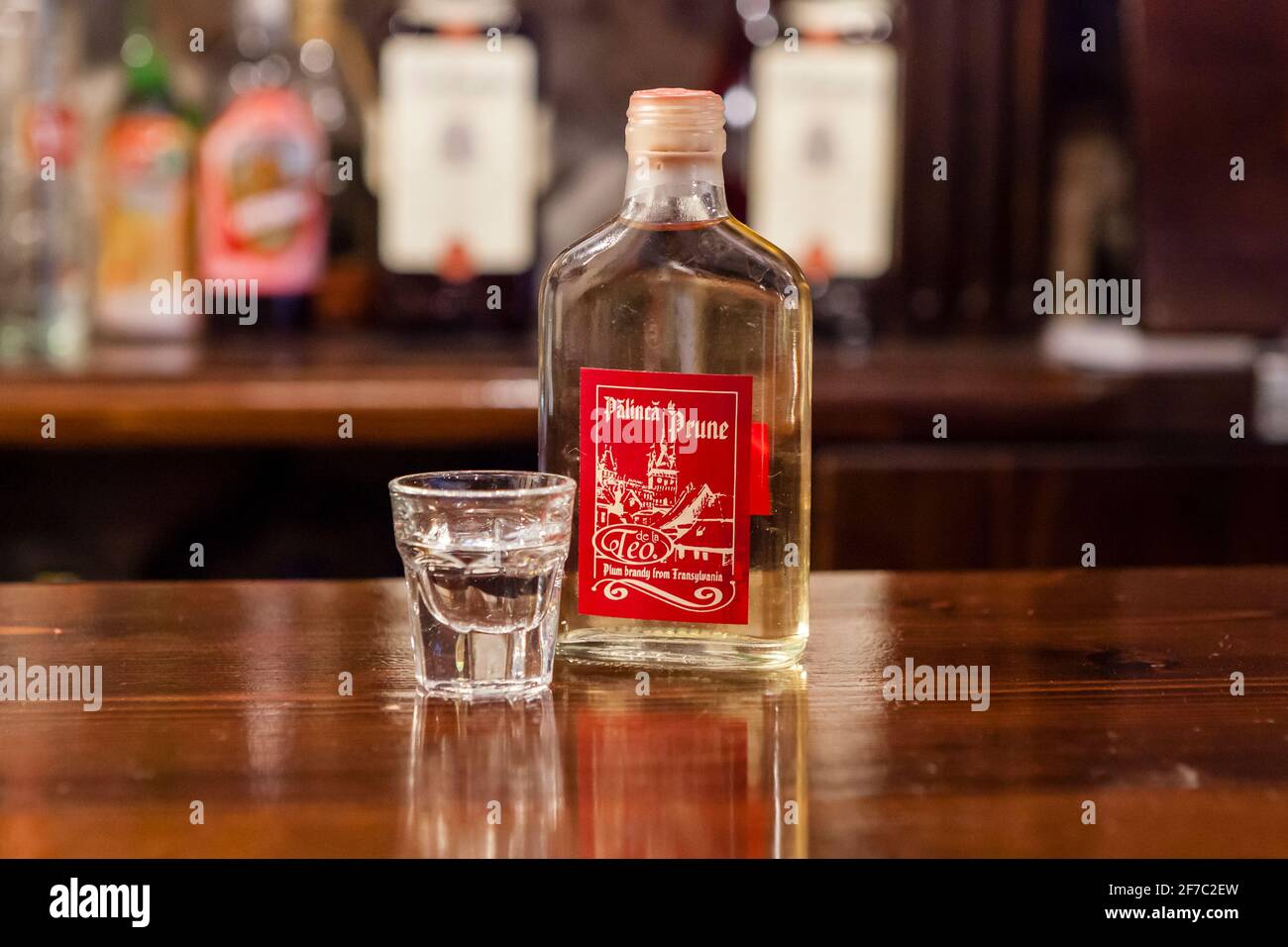 A bottle of Palinca plum brandy and serving cup, as served in ...