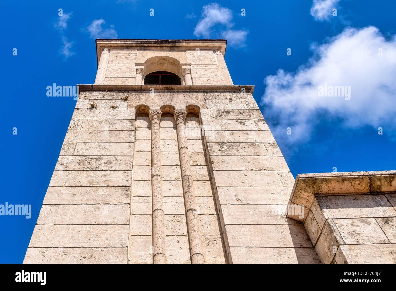 Stone bell tower with classical columns viewed from below under a ...