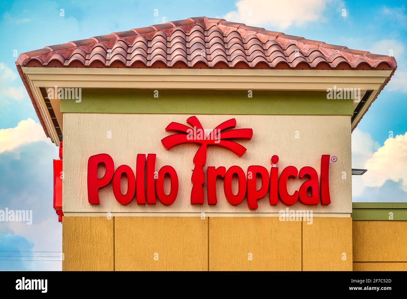 Pollo Tropical restaurant sign on building facade with tile roof under ...