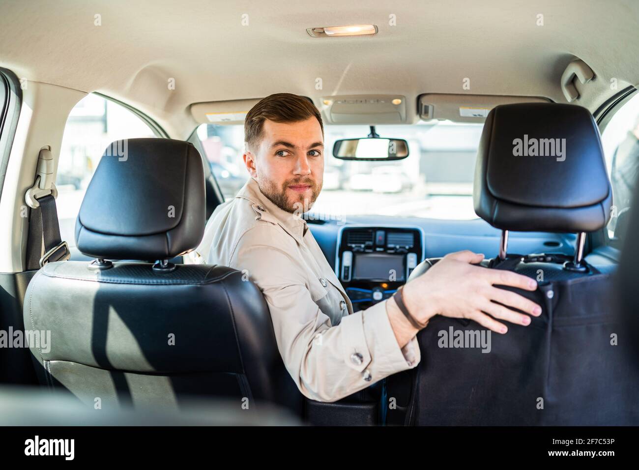 Male driver is reversing on the car. Man looks into the rear window of ...