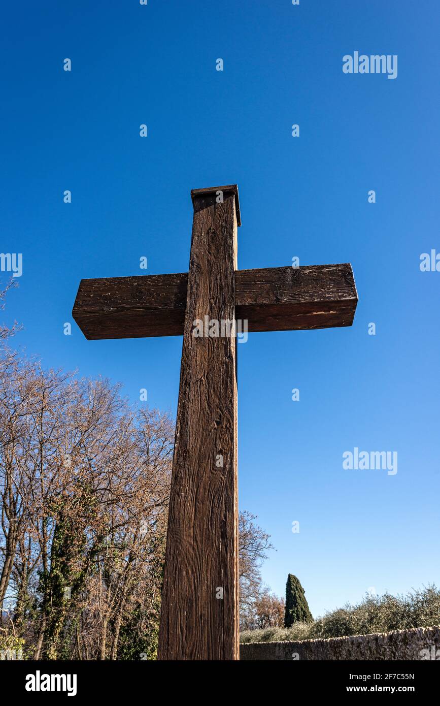 Closeup of a wooden Christian cross on a clear blue sky in a rural ...