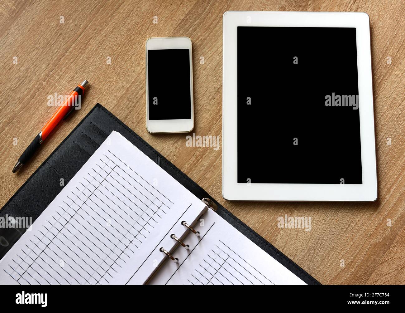 Open book,tablet computer and smartphone on working desk. Office ...