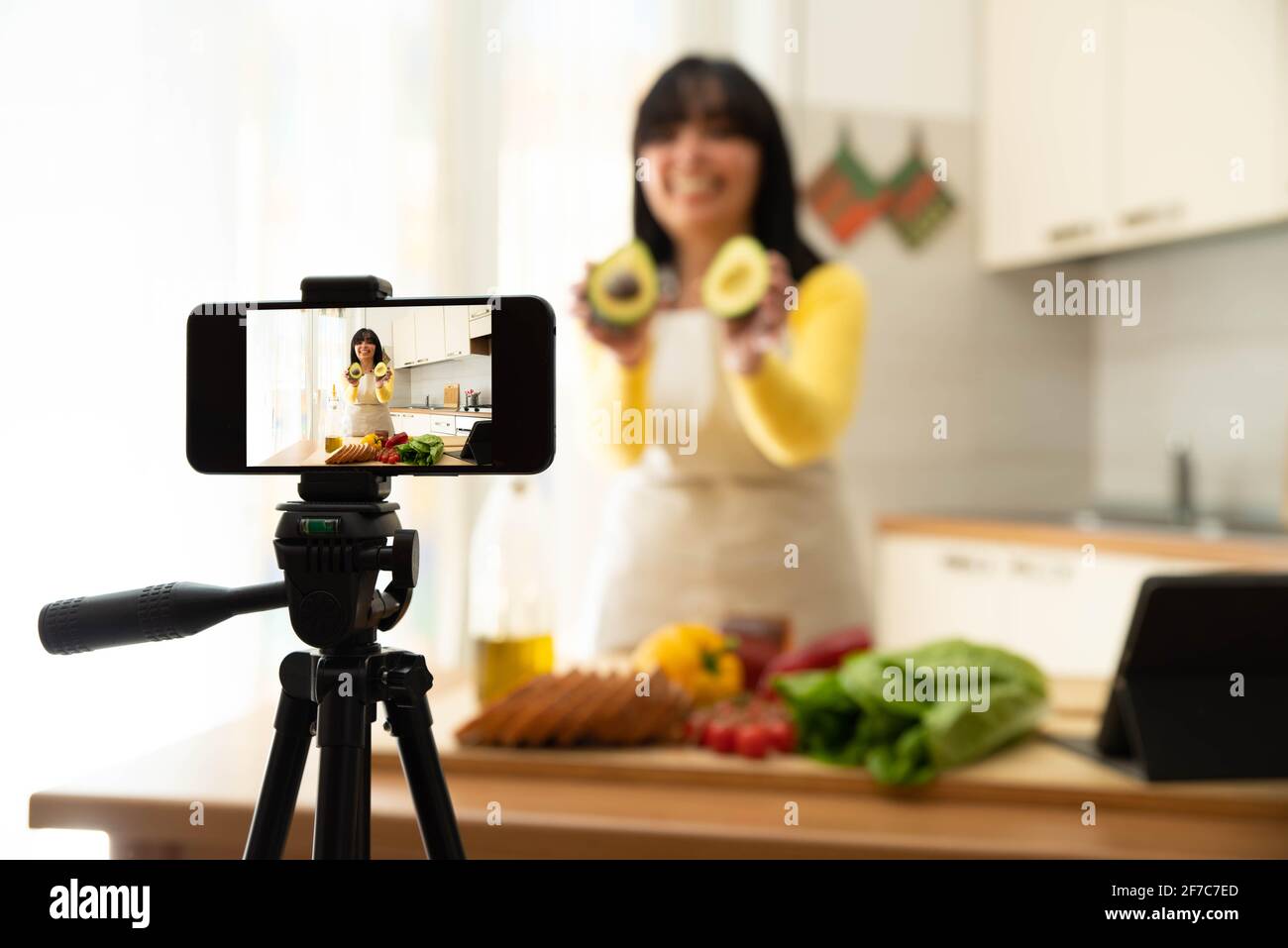 Woman cooking healthy food in the kitchen - Food blogger recording ...