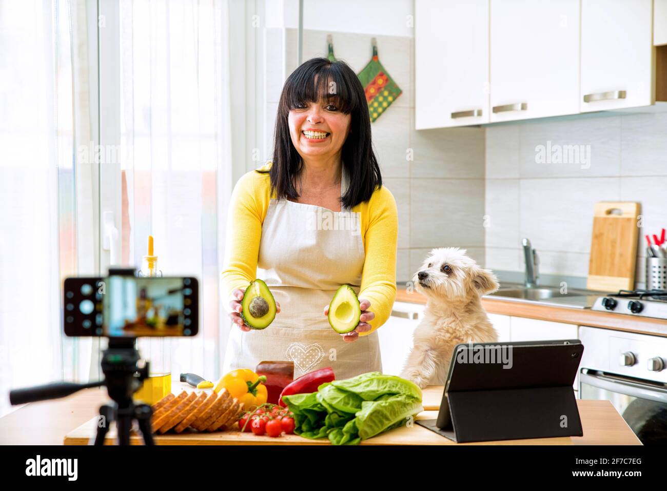 Woman cooking healthy food in the kitchen - Food blogger recording ...