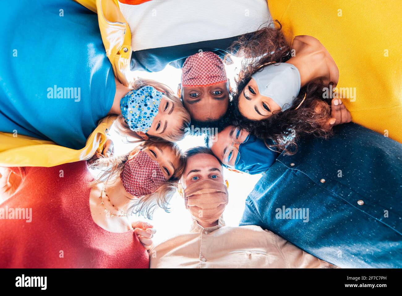 Multiracial group of friends wearing protective face masks taking a ...
