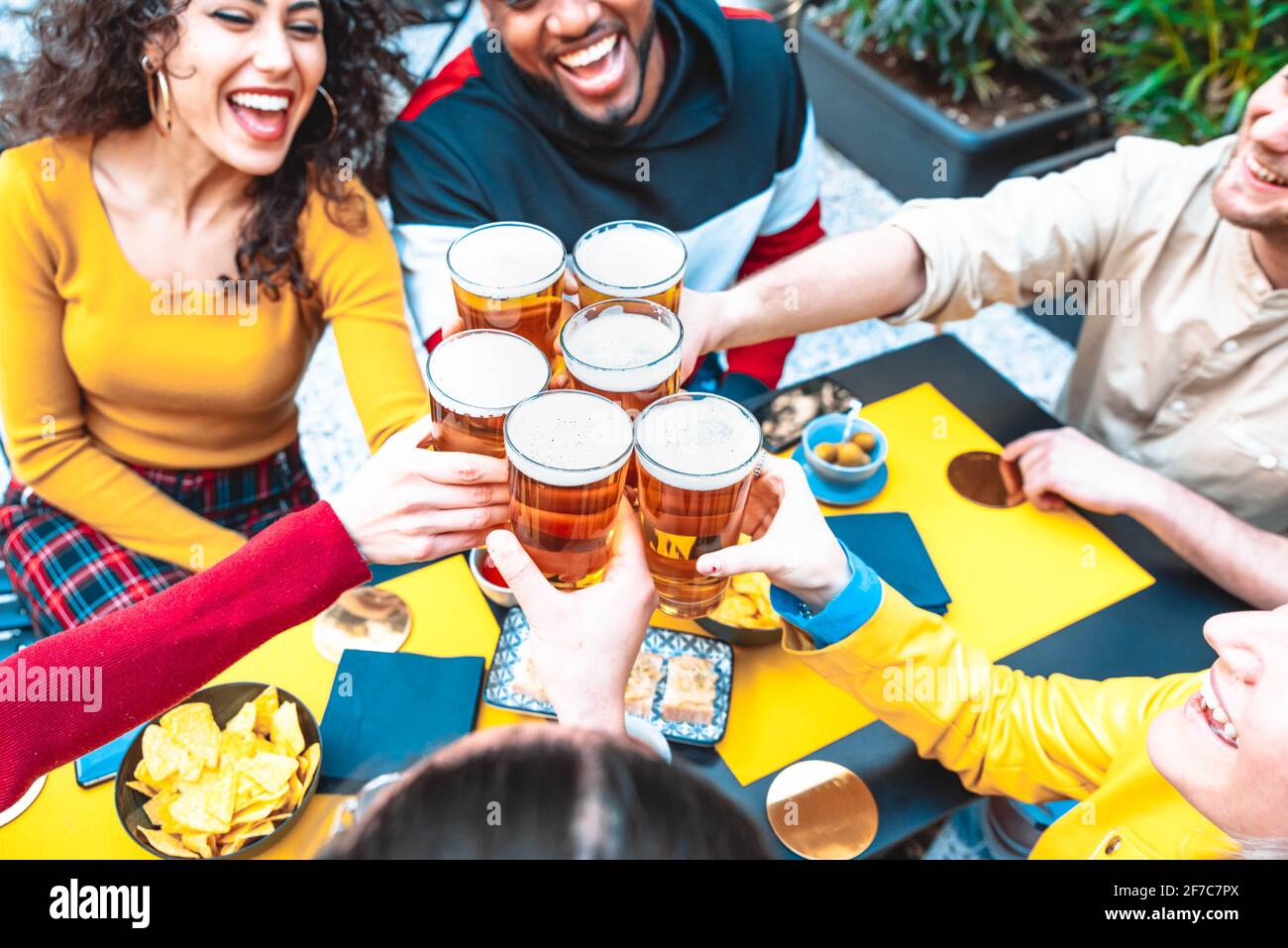 Group of multicultural friends drinking and toasting beer at brewery ...