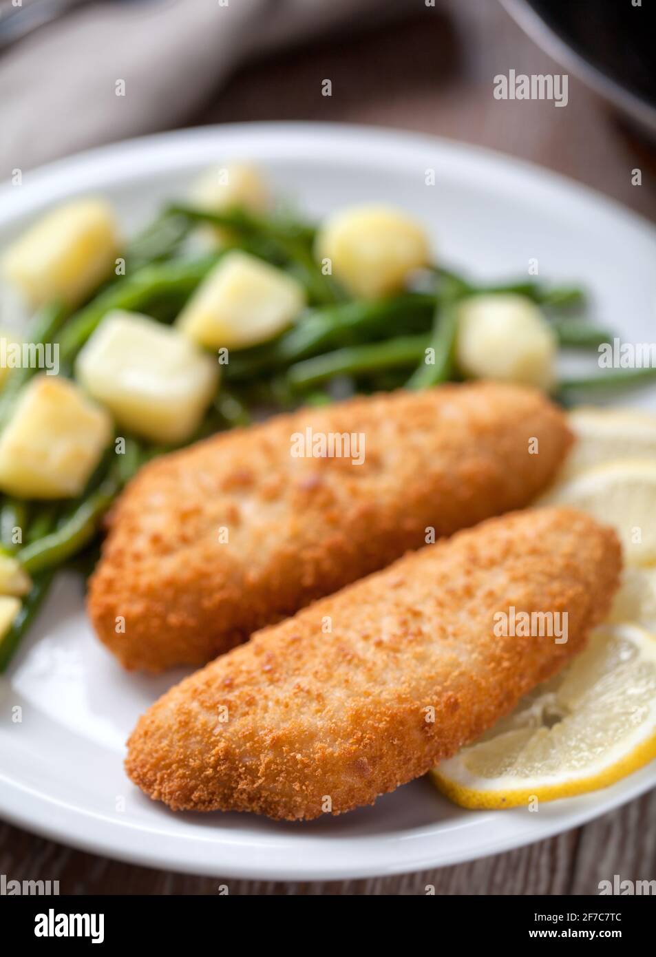 Breaded Fish Fillet with Potatoes and Green Beans Stock Photo - Alamy