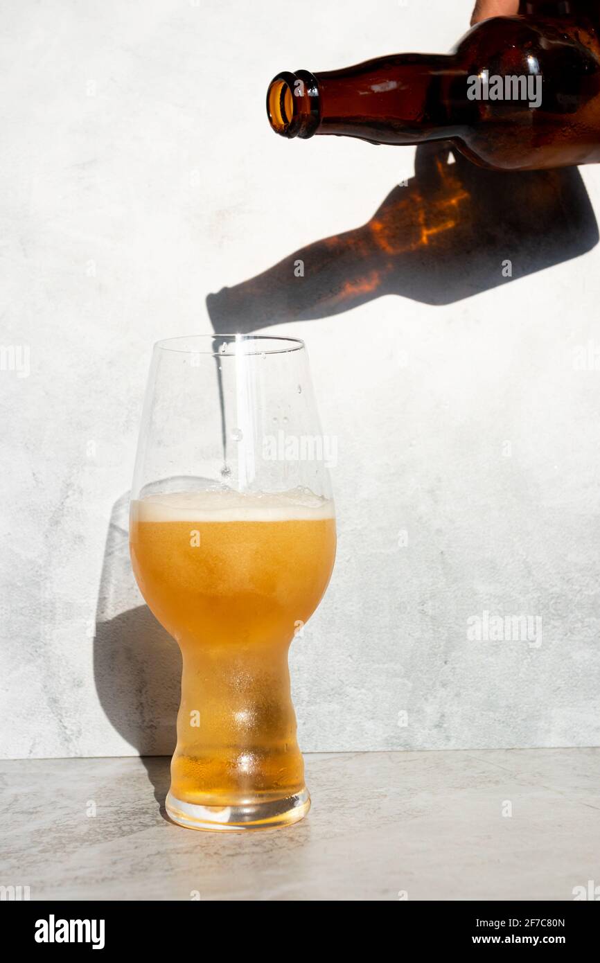 Serving beer, from a bottle to a crystal glass for IPA Stock Photo - Alamy