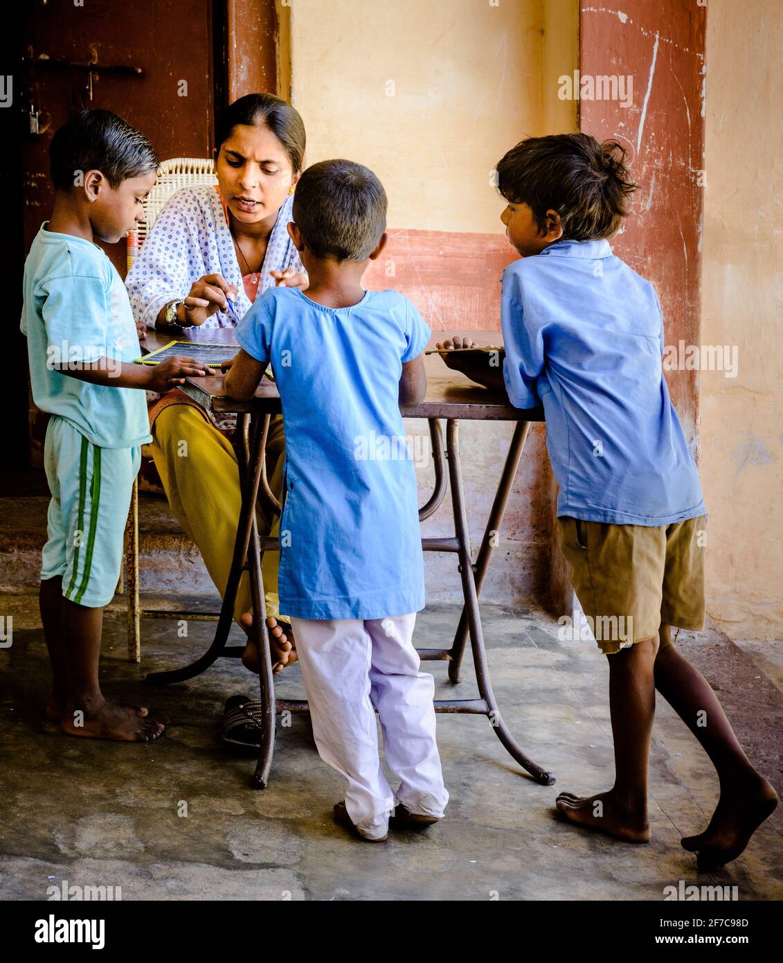 Teacher tutoring three pupils in small village school in India Stock ...