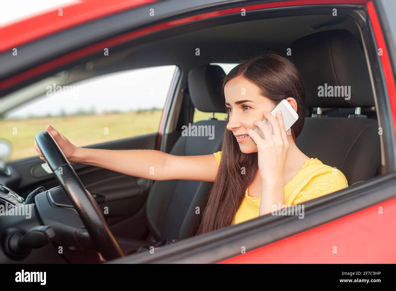 Woman talking on the phone while driving a car Stock Photo - Alamy