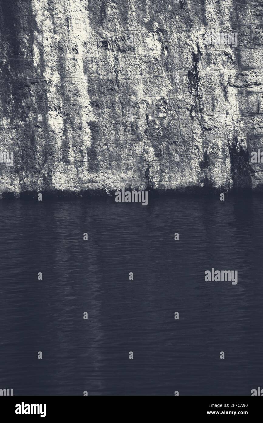 Bridge stone wall reflection in water. Abstract texture background ...