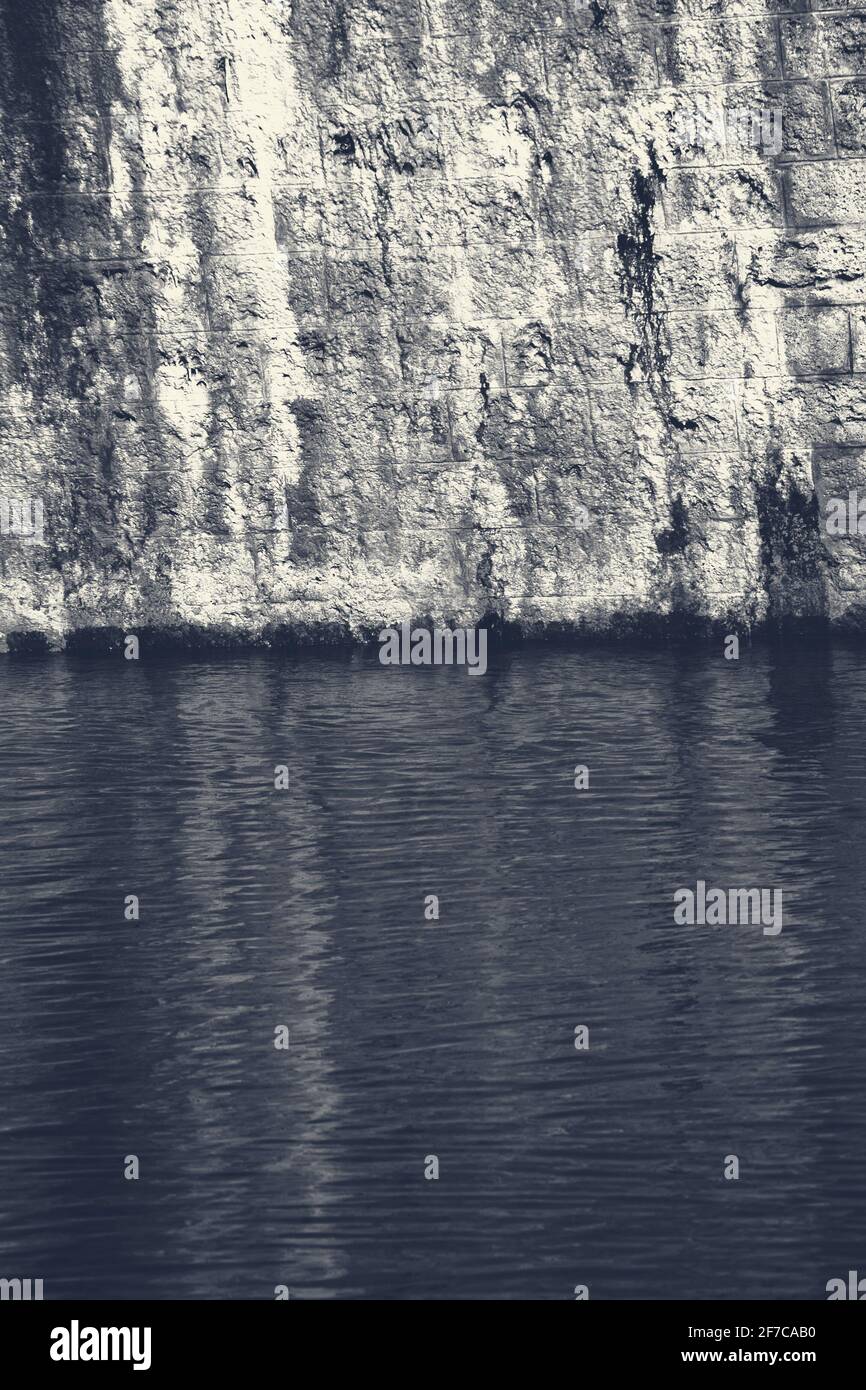 Bridge stone wall reflection in water. Abstract texture background ...
