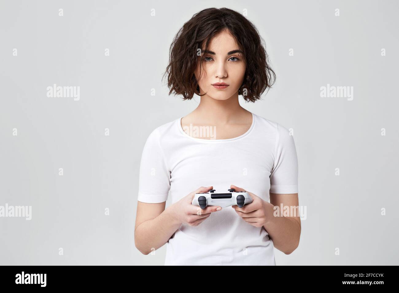 beautiful curly girl playing video games on gray background Stock Photo ...