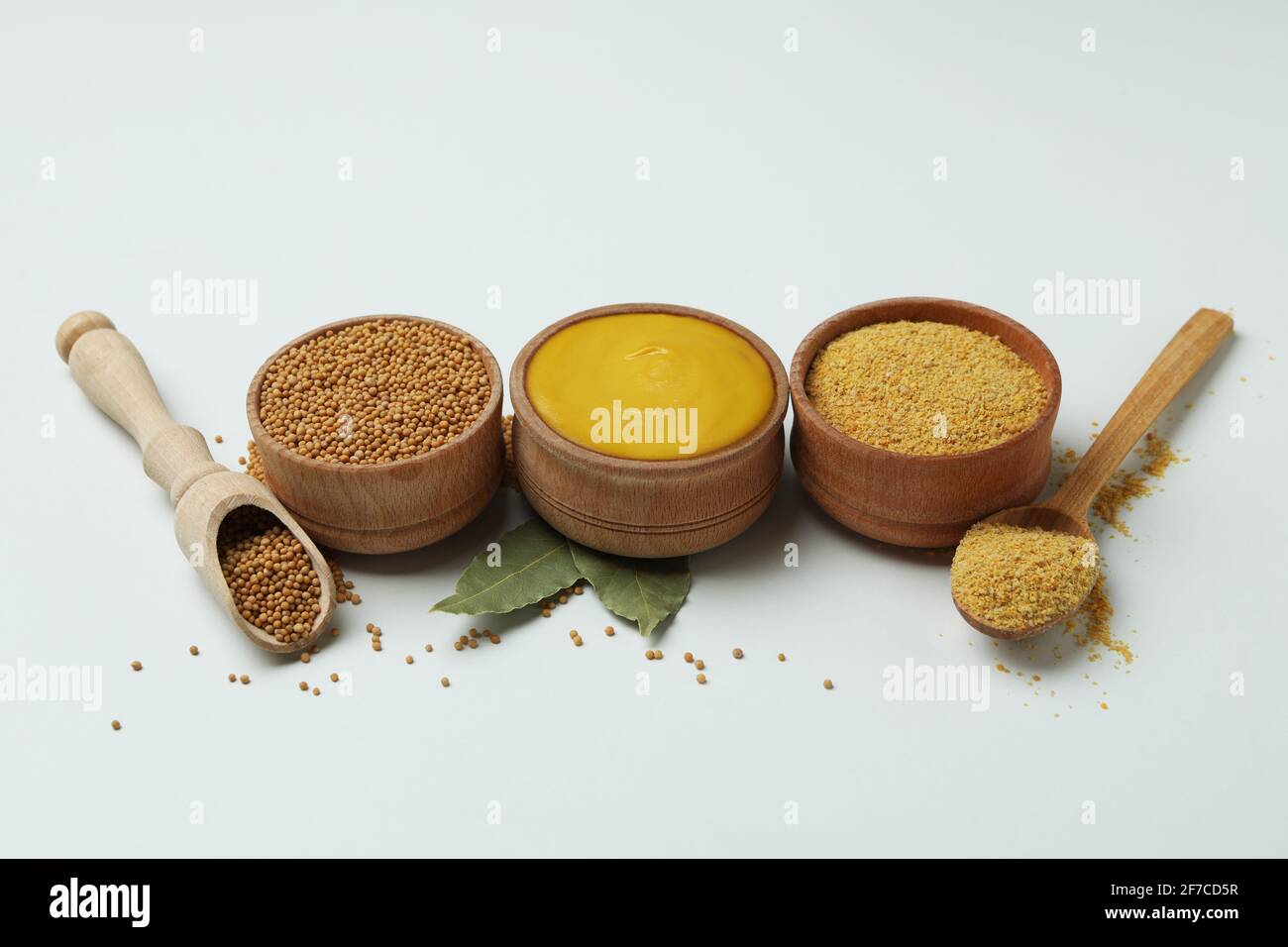 Bowls with mustard seeds, sauce and powder on white background Stock ...