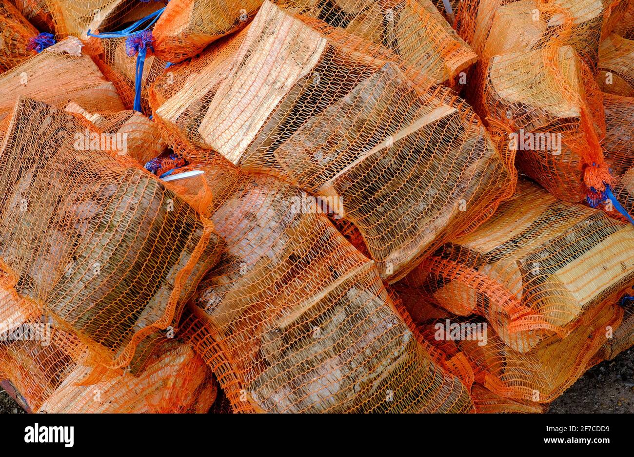 bundles of chopped timber logs wrapped in plastic orange mesh, norfolk ...