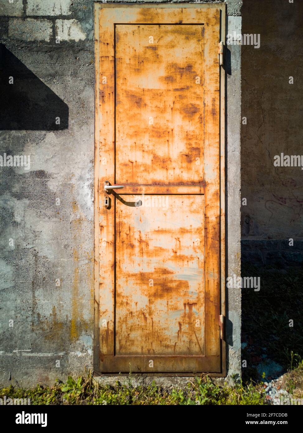 Detail of a rusty door of a factory. Frontal view. Nobody inside. Copy ...