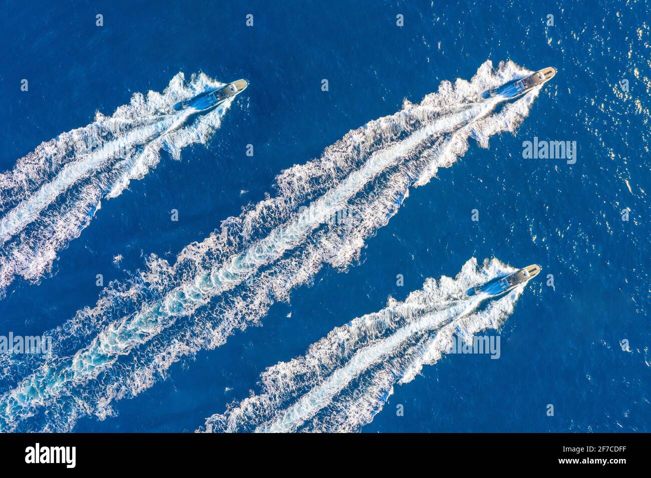 Three speed boats launch at high speed floats in the ocean, aerial top ...