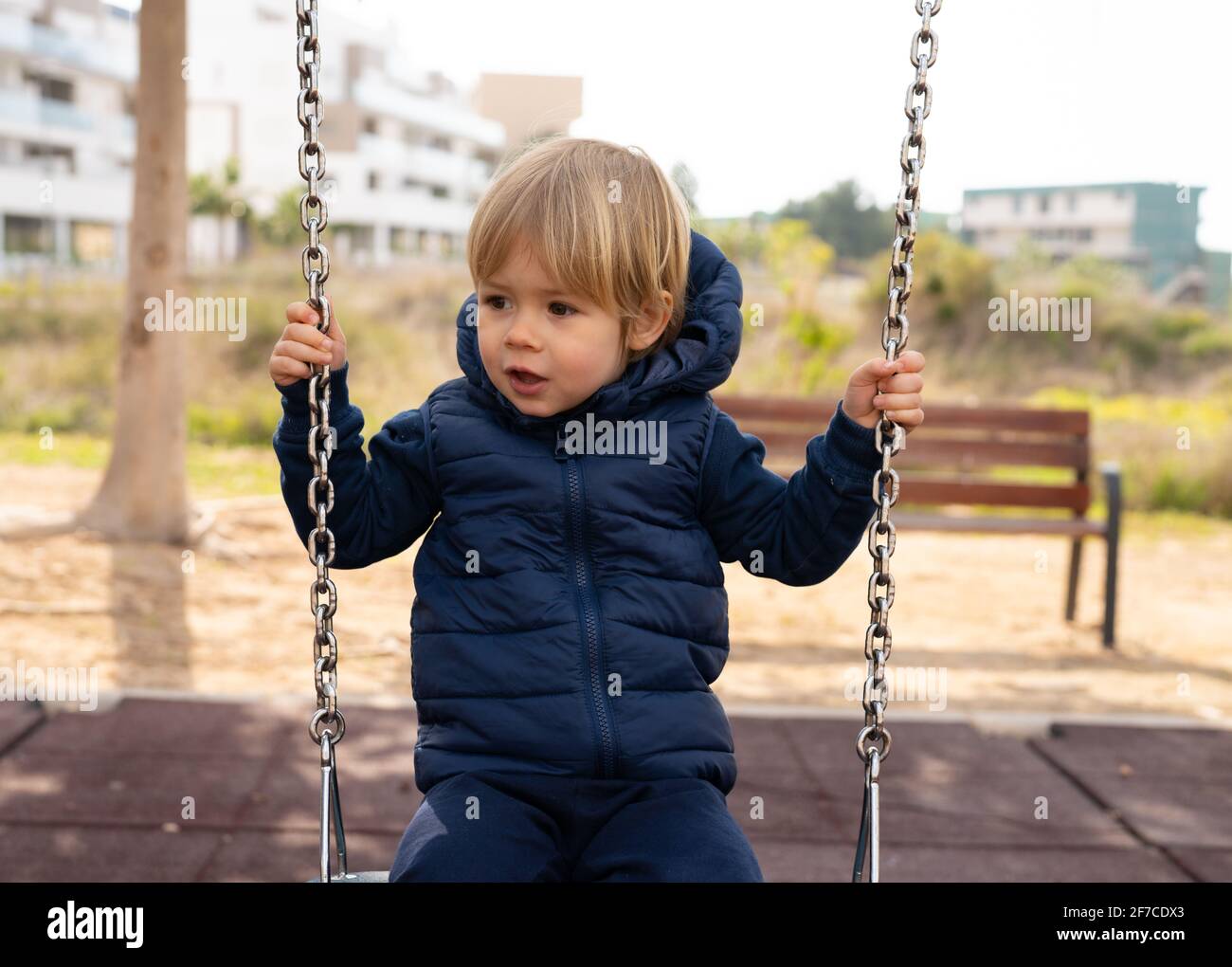The child is riding on a swing. Boy playing outside Stock Photo - Alamy