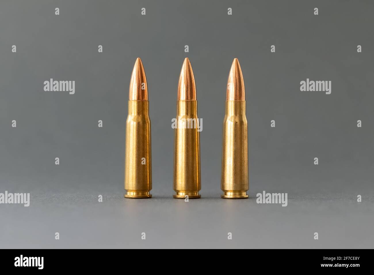 Three bullets on gray background. Cartridges 7.62 caliber for ...