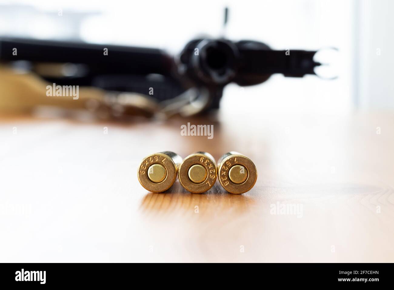 Three bullets bottom against blurred Kalashnikov assault rifle ...