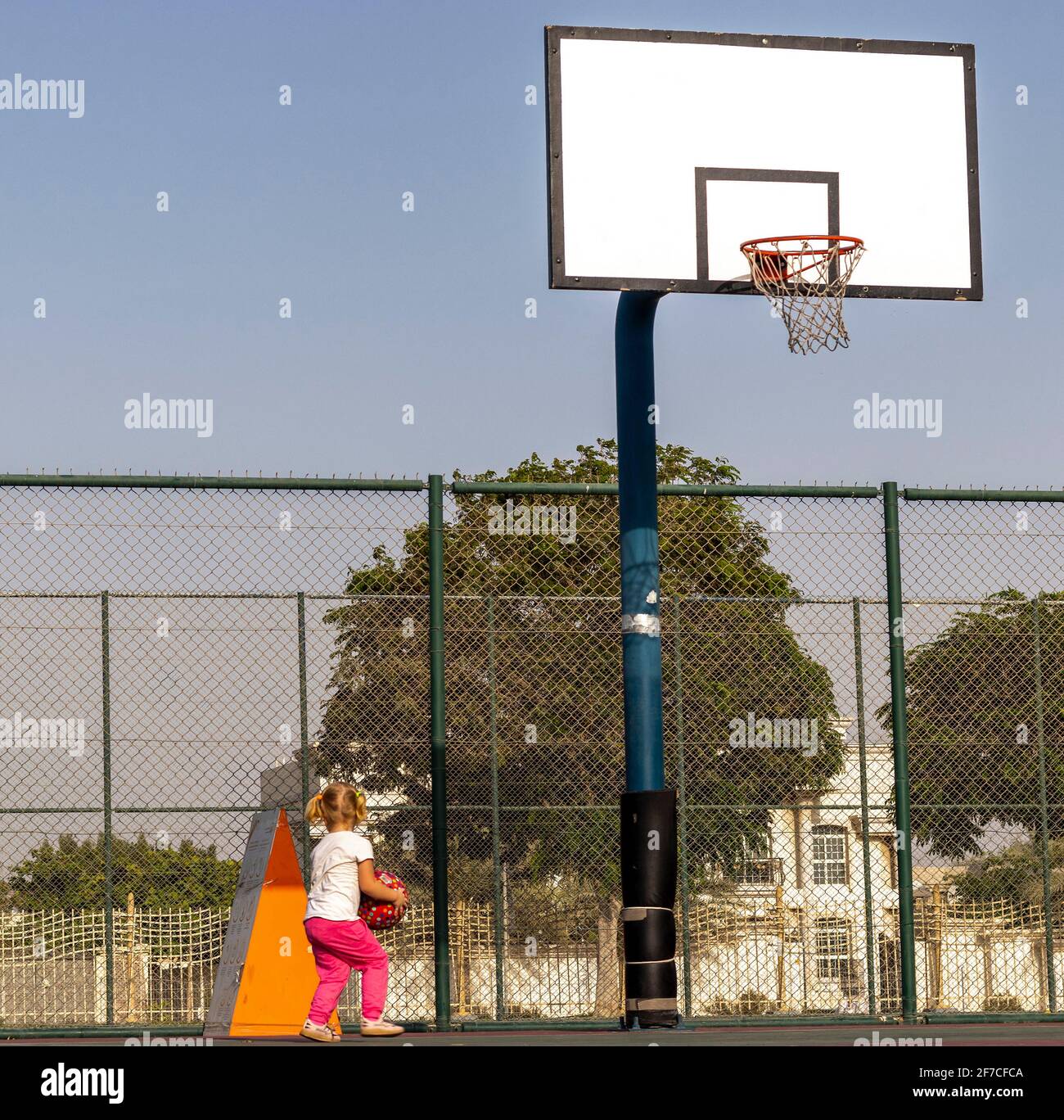 Little girl playing with the ball on the basketball court Stock Photo ...