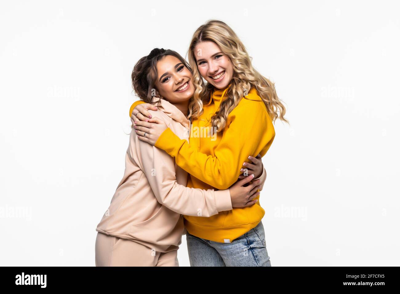 Portrait of two women smiling hugs and having fun, isolated on white ...