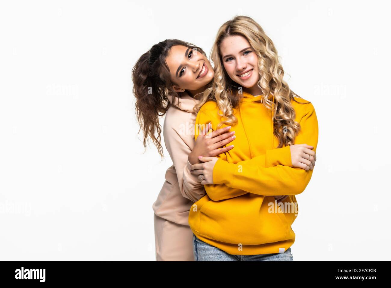 Portrait of two women smiling hugs and having fun, isolated on white ...