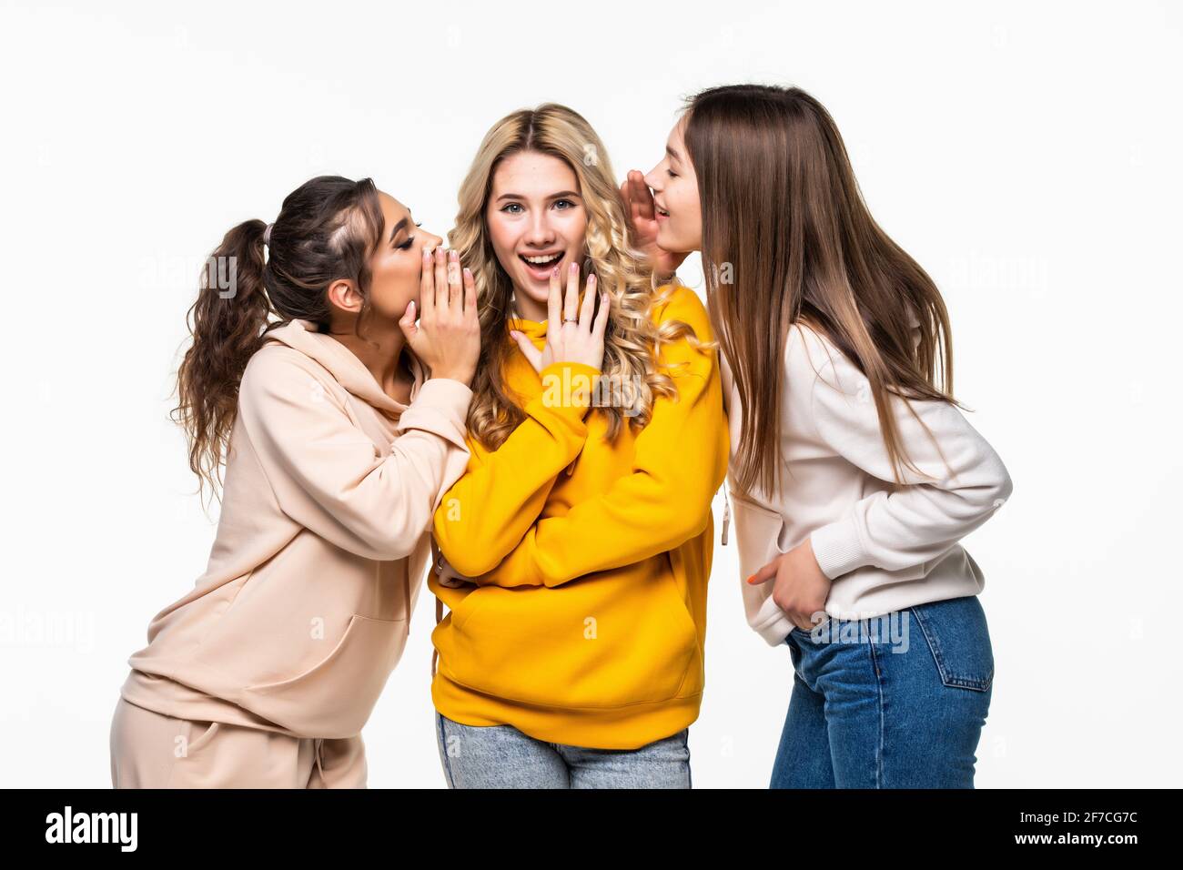 Three attractive girls gossiping. Isolated on white Stock Photo - Alamy