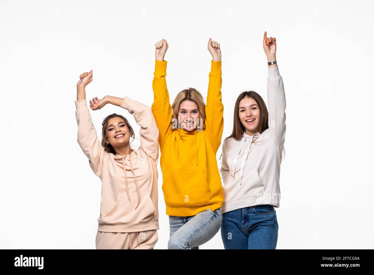three young women dancing over white background Stock Photo - Alamy