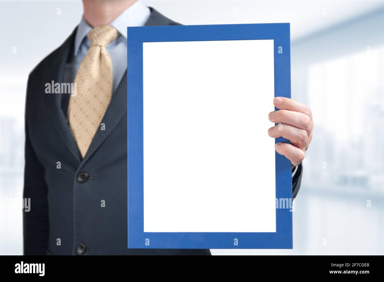 businessman holds mockup frame with blank white space for certificate ...