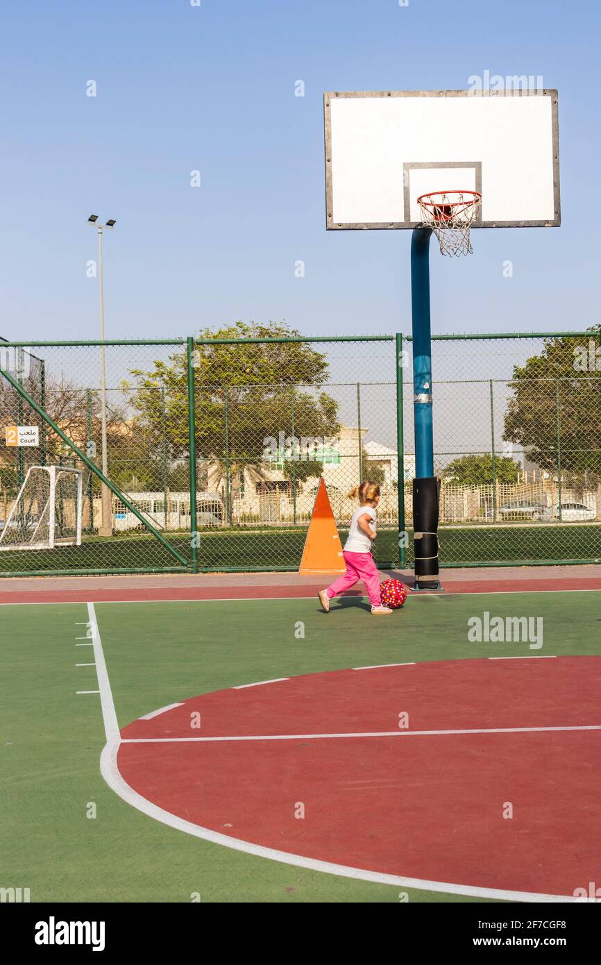 Little girl playing with the ball on the basketball court Stock Photo ...