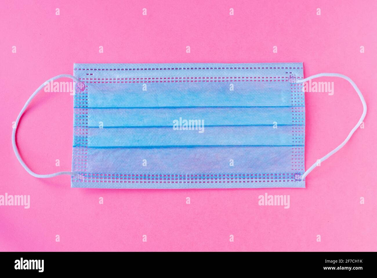 Blue protective medical face mask on a pink background. Respiratory ...