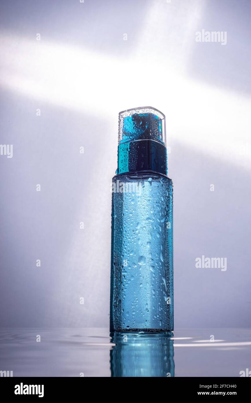 moisturizing the skin. A blue bottle with a liquid for moisturizing the ...