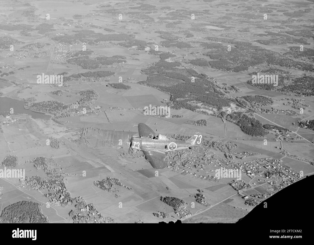 Airplane j 9 in the air over fields. A camouflage painted hunting ...