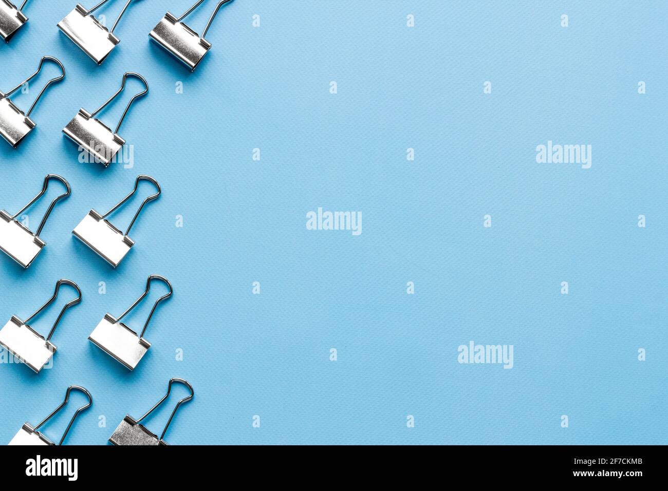 Frame of silver paper binder clips top view. Office supplies pattern ...