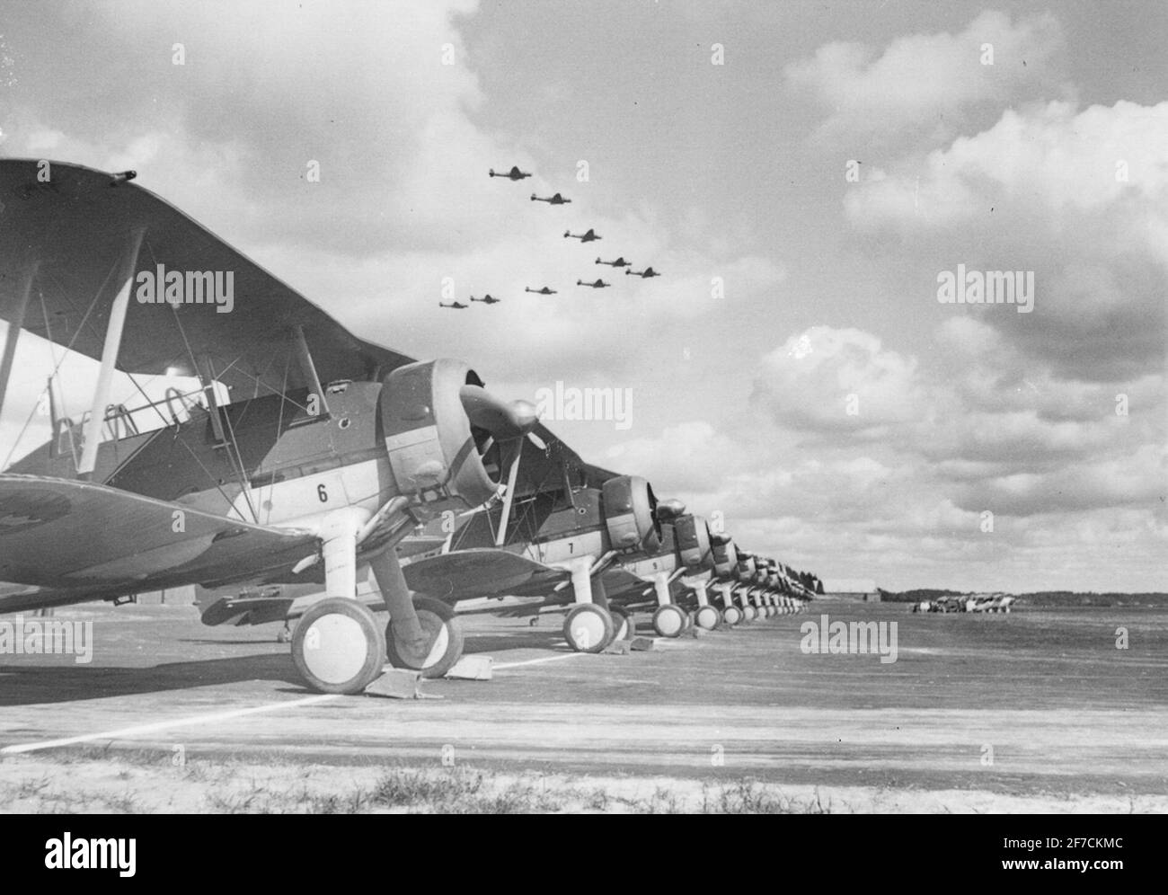 Aircraft B 3 flies over aircraft J 8 on airfield, 1938. Nine bombers B ...
