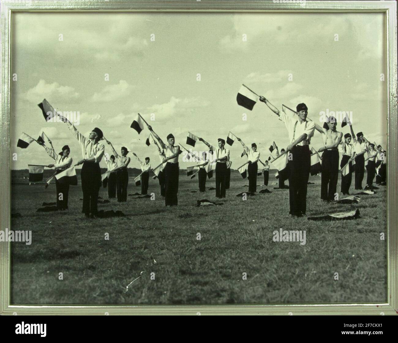 Consignable men practice signaling with flags against aircraft ...