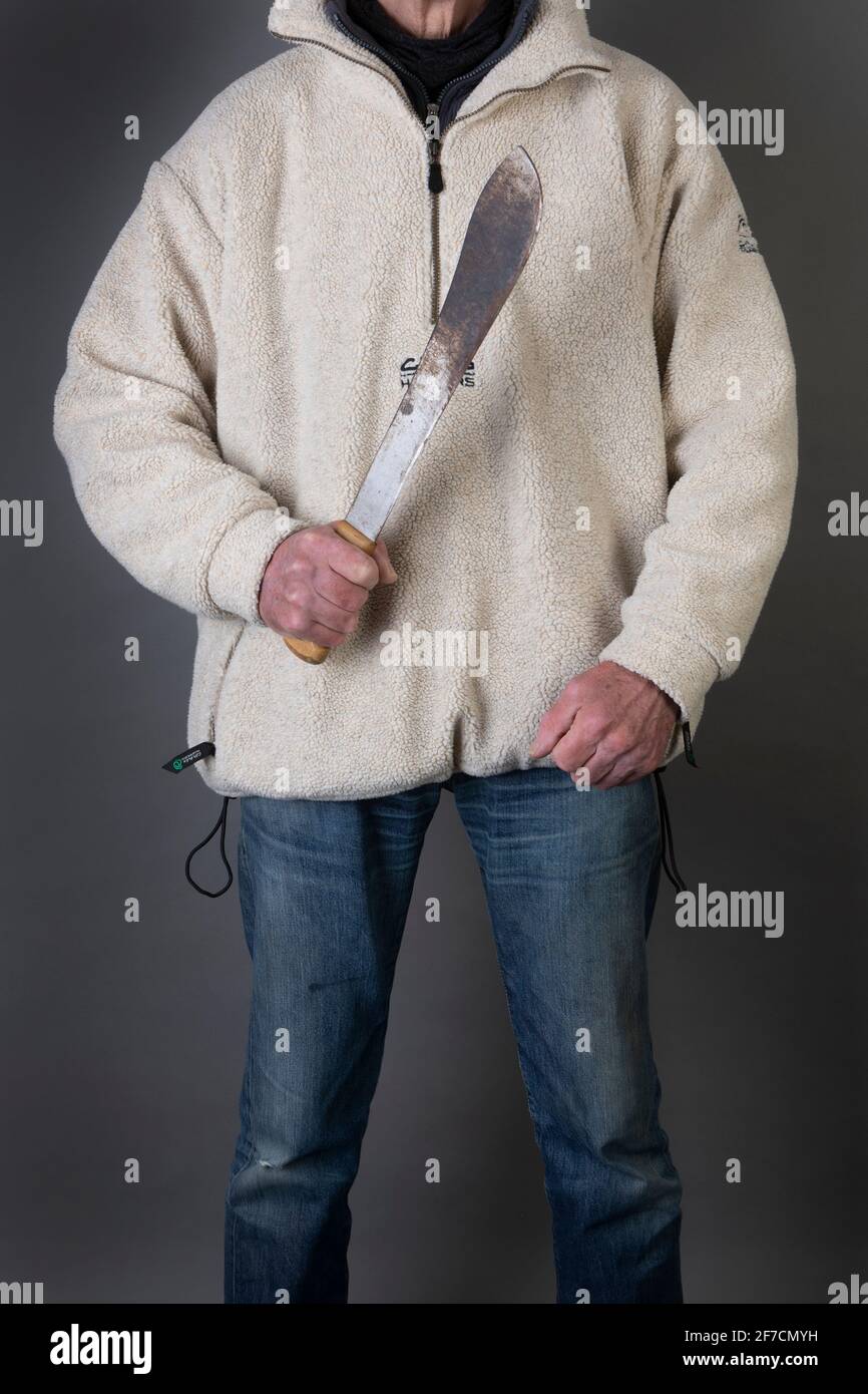 A man holding a machete in a threatening manner Stock Photo - Alamy