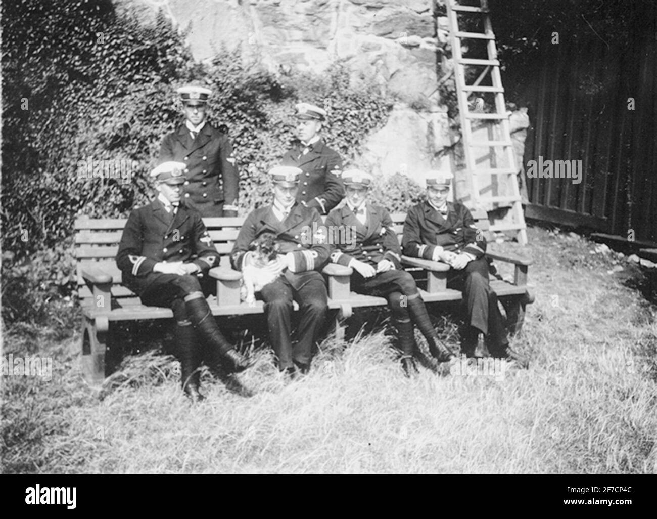 Six officers and a dog posing at a bench. Six officers and a dog posing ...