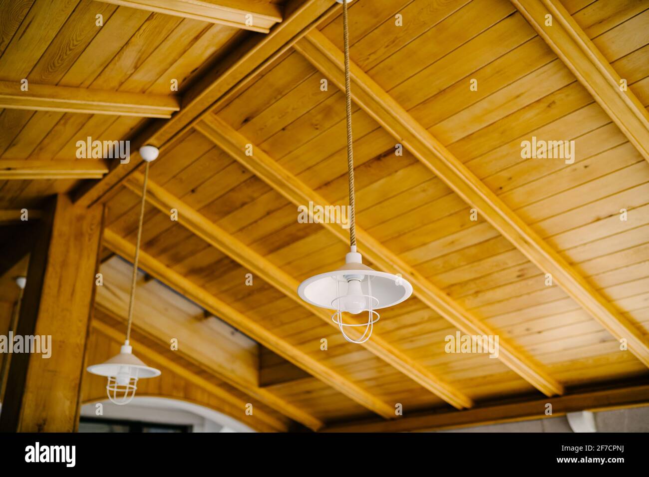 Modern minimalist light fixture under a wooden ceiling Stock Photo - Alamy